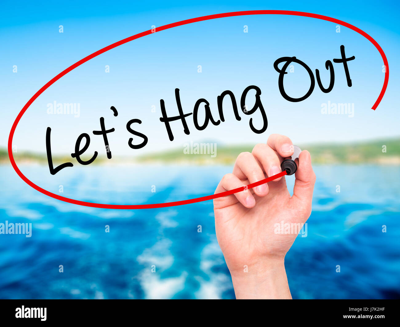 Man Hand writing Let's Hang Out with black marker on visual screen ...