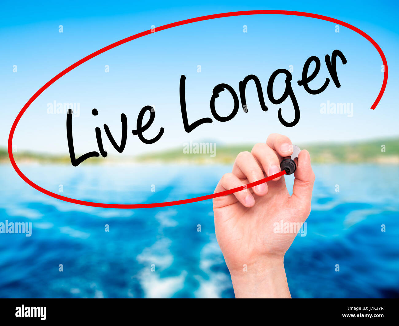 Man Hand writing Live Longer with black marker on visual screen ...