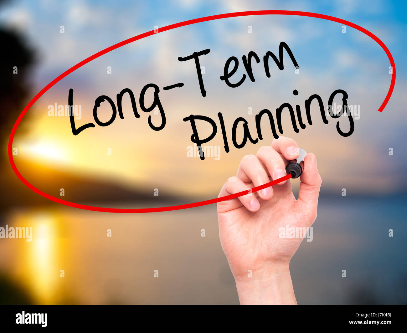 Man Hand writing Long-Term Planning with black marker on visual screen ...