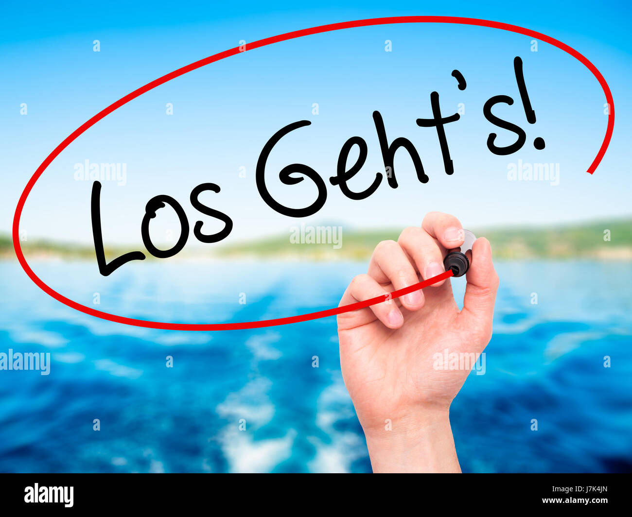 Man Hand writing Los geht's! (Here We Go in German) with black marker ...