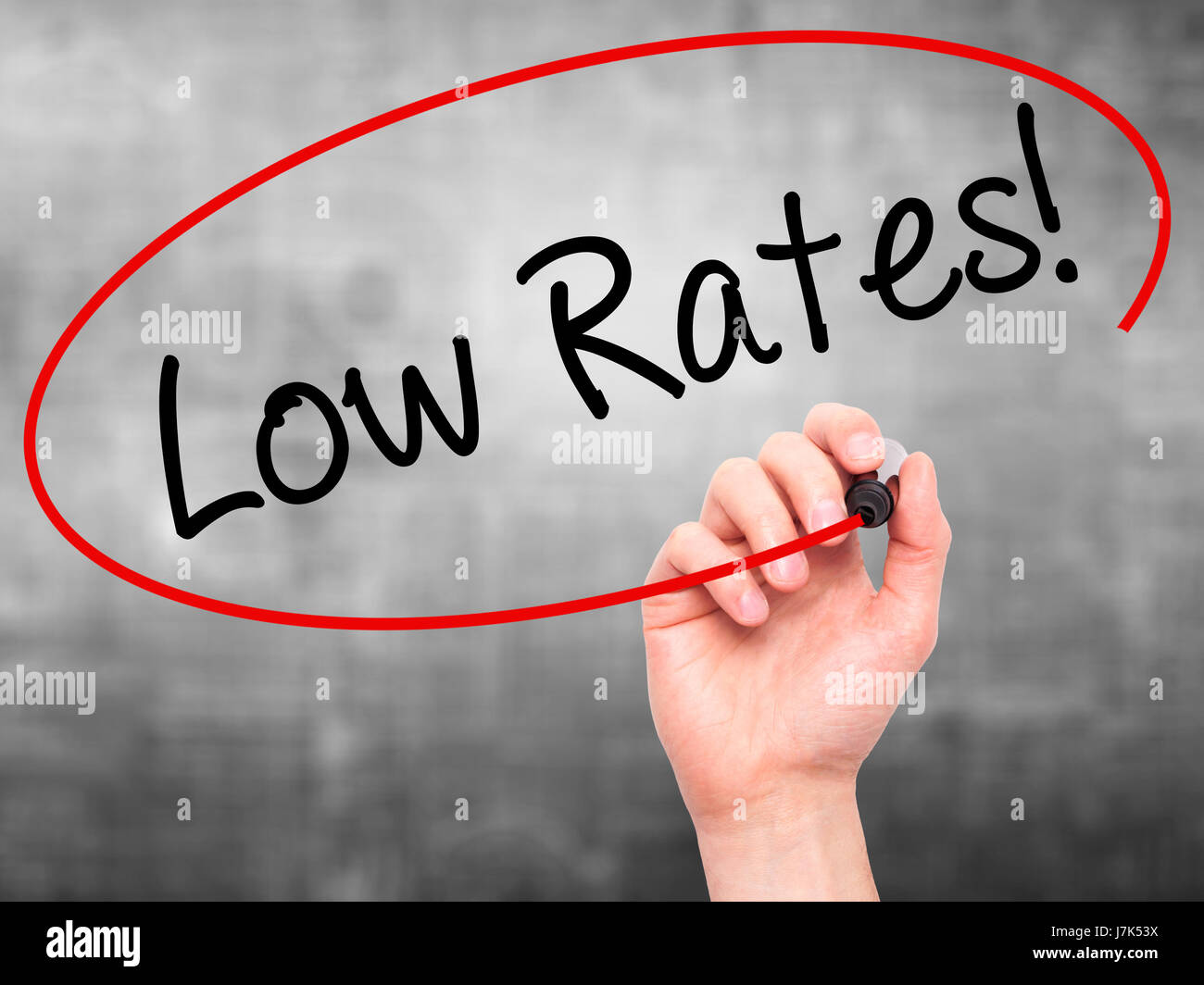 Man Hand writing Low Rates! with black marker on visual screen ...