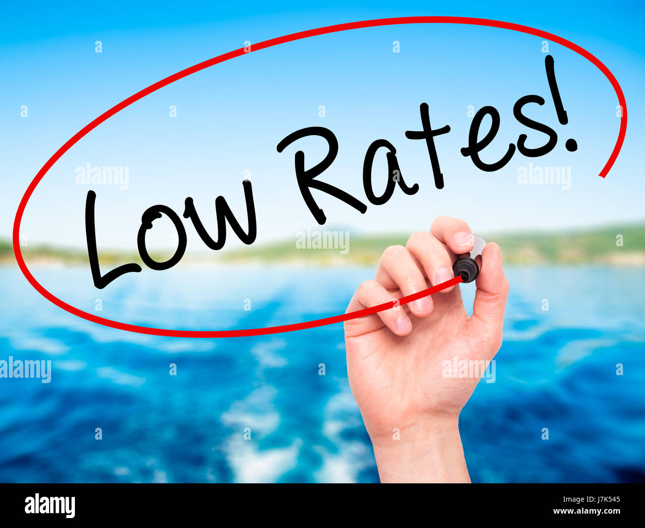 Man Hand writing Low Rates! with black marker on visual screen ...
