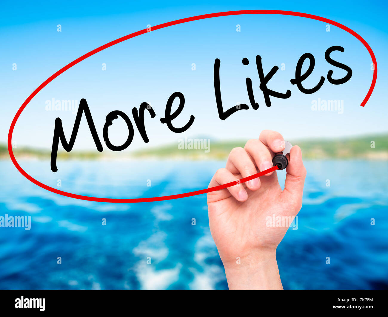 Man Hand writing More Likes with black marker on visual screen ...