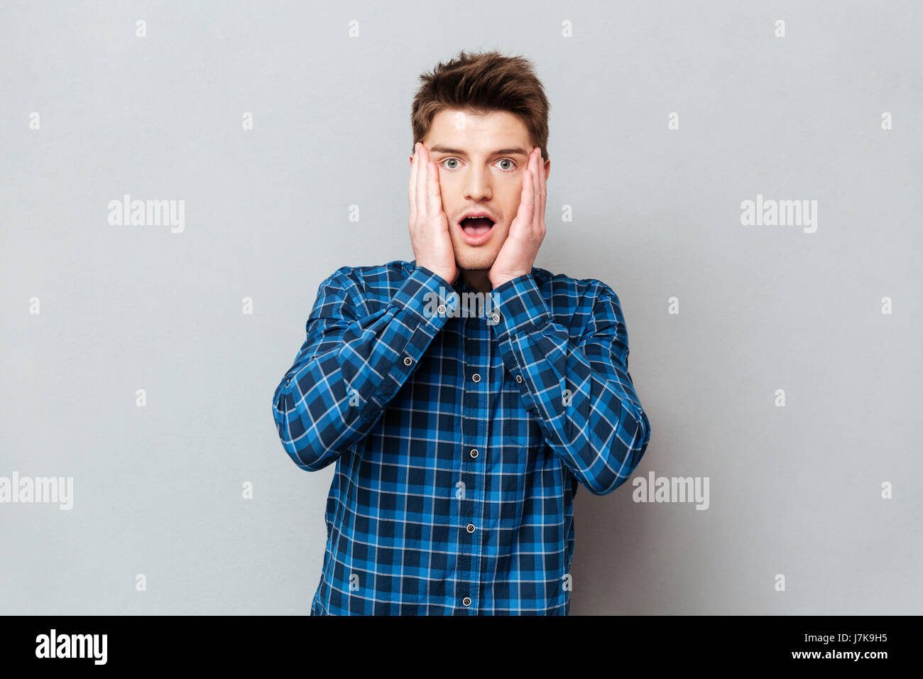 Young handsome man shocked and surprising at camera isolated Stock ...