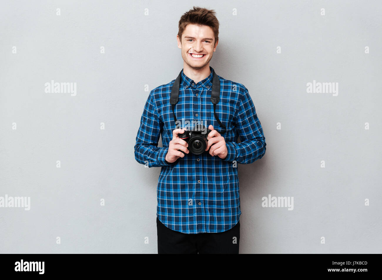 Cheerful and laughing man with camera posing isolated Stock Photo - Alamy