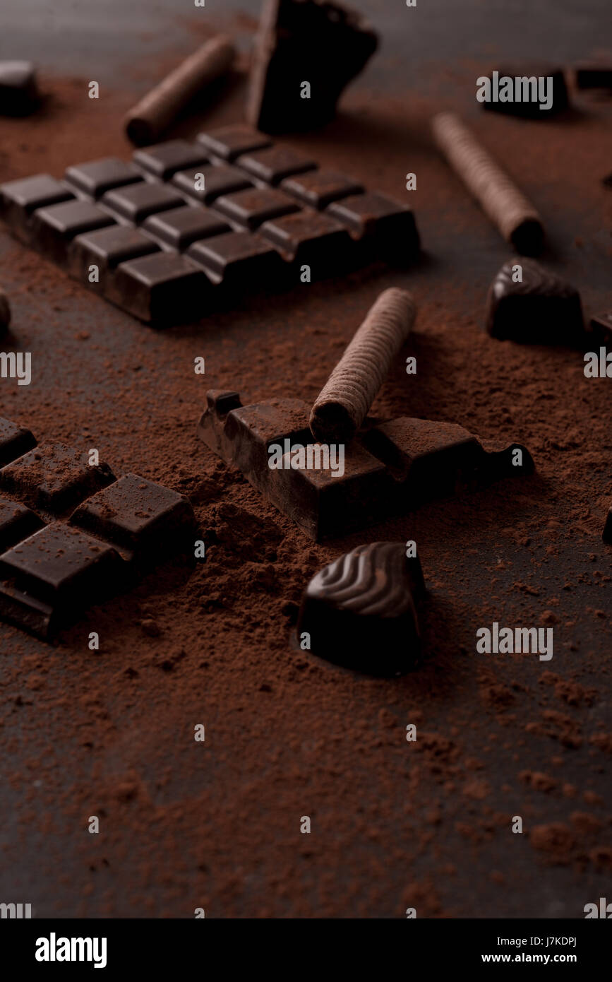 Close up of chocolate bar crashed into pieces with candies spread all ...