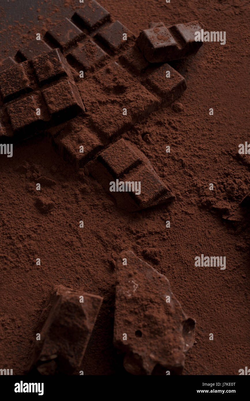 Top view of dark chocolate blocks crashed into pieces over wooden ...