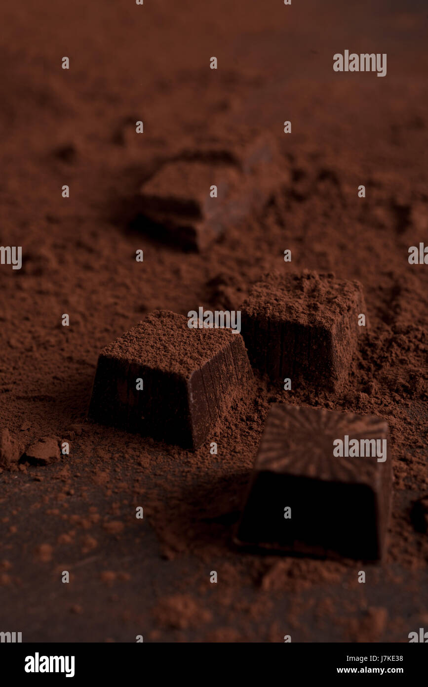 Close up of chocolate candies covered with dark powder on a table Stock ...