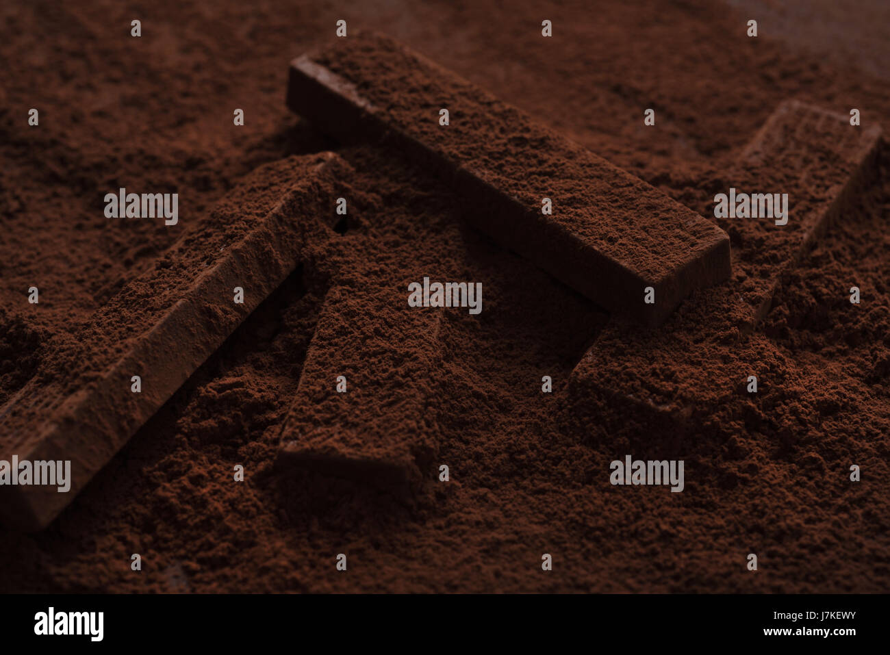 Close-up of chocolate bar pieces laying in chocolate powder on a ...