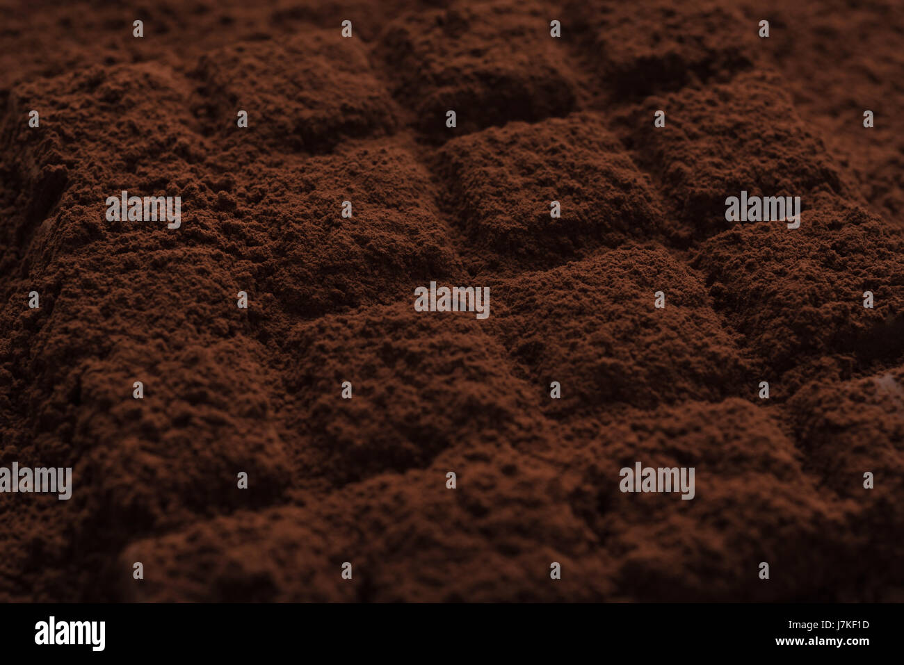 Close-up of a natural dark chocolate piece covered in powder on a ...