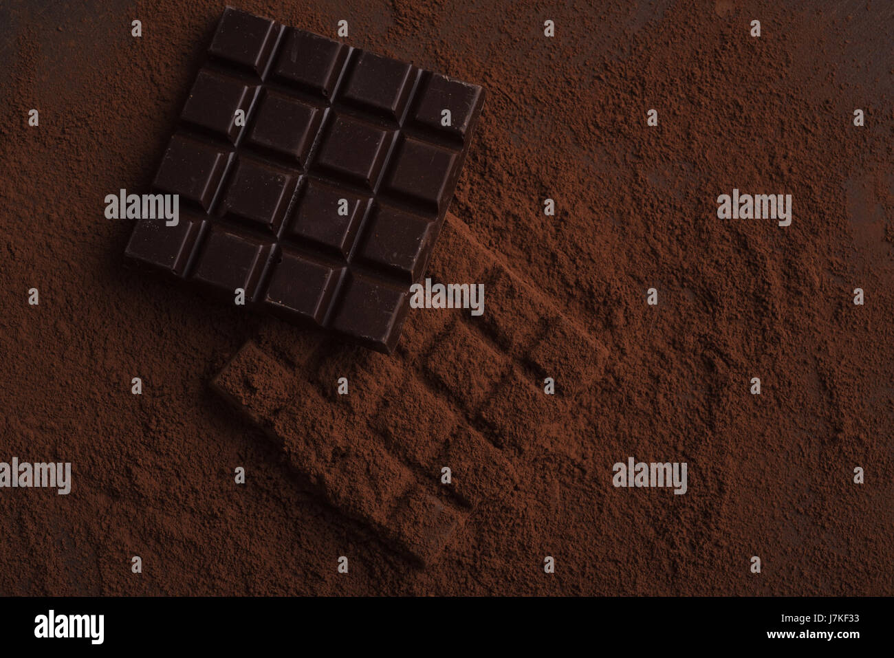 Top view of dark and milk square chocolate bars covered in powder on a ...
