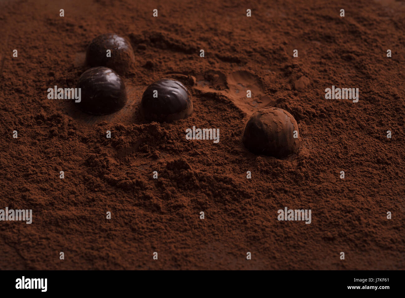 Close-up of chocolate candies over chocolate powder background Stock ...