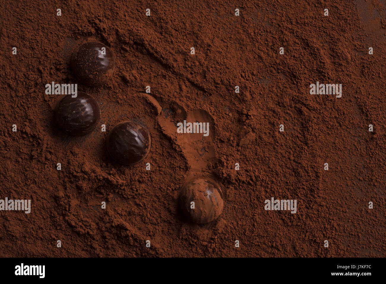 Close-up of chocolate candies over chocolate powder background Stock ...