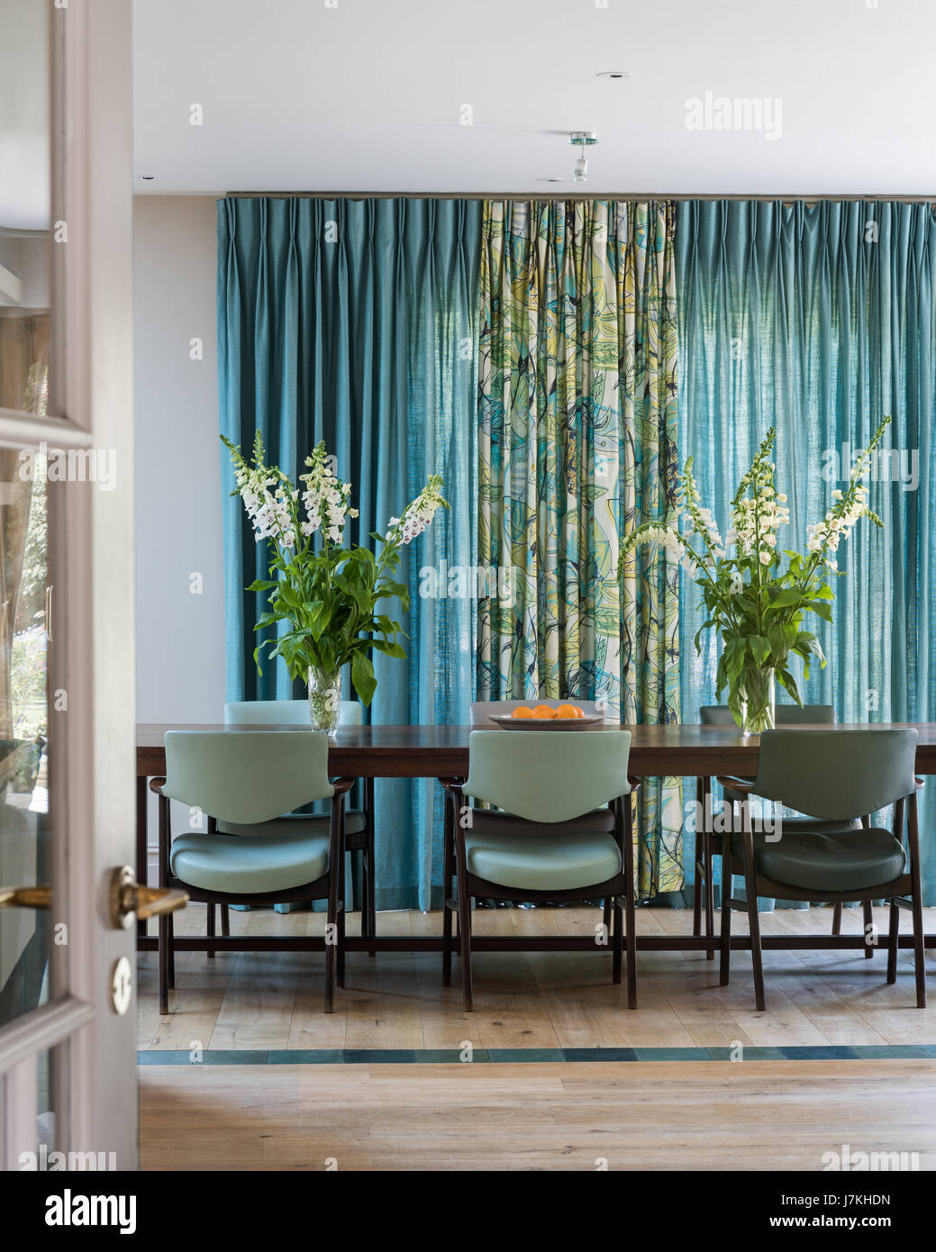 Salvaged Iroko table in dining room with leather chairs and pineapple ...