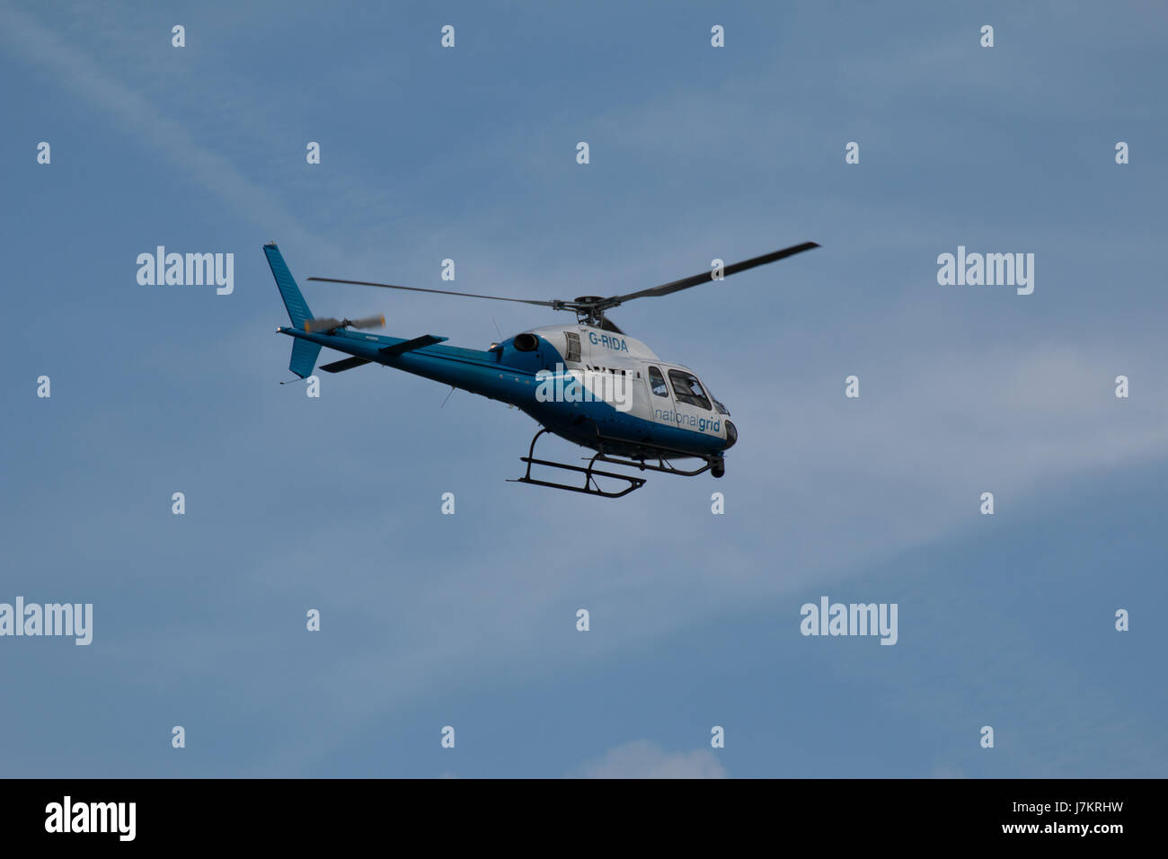 Blue and White Helicopter flying over head Stock Photo - Alamy