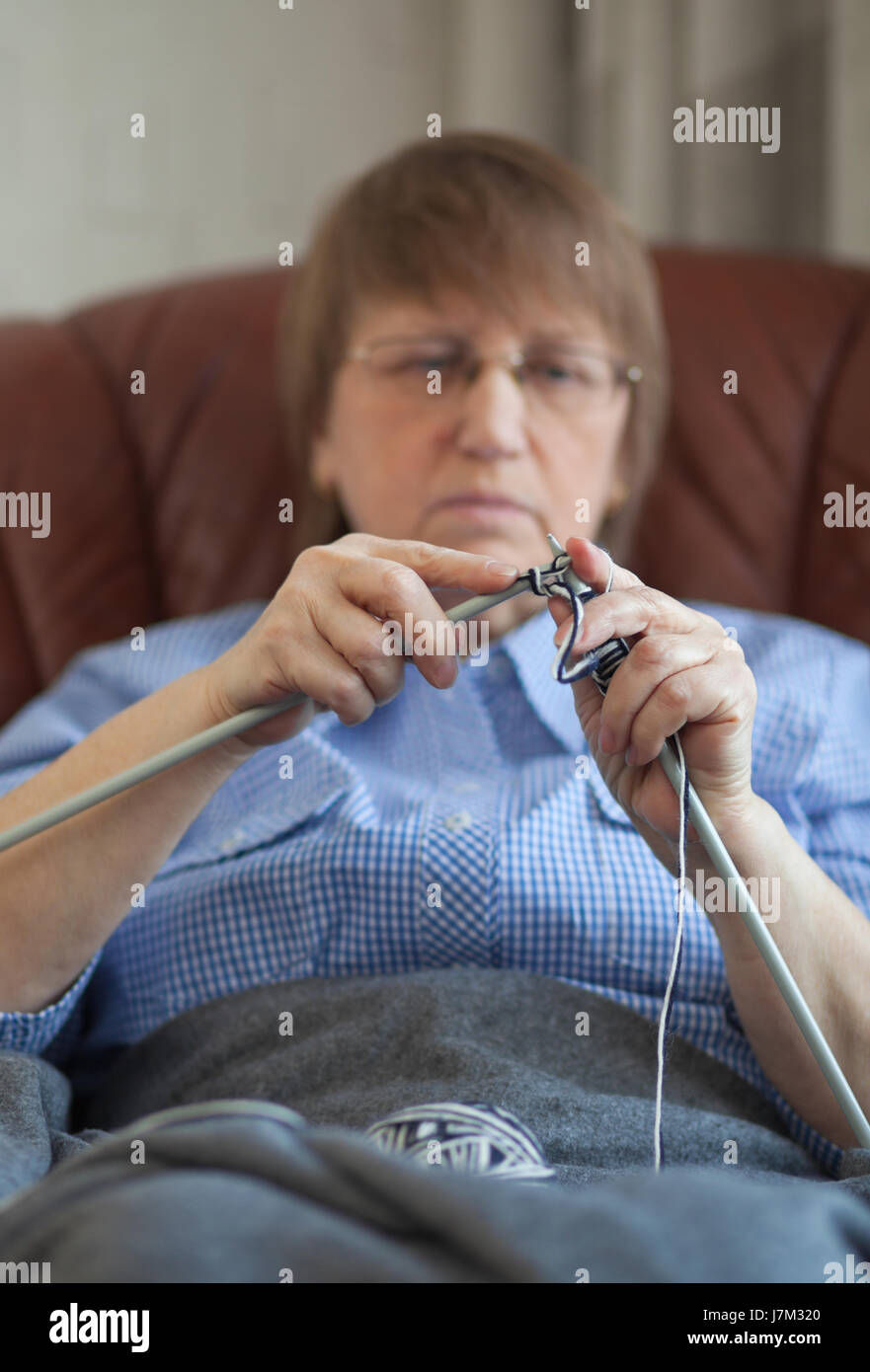 woman armchair hand hands spectacles glasses eyeglasses thread ...