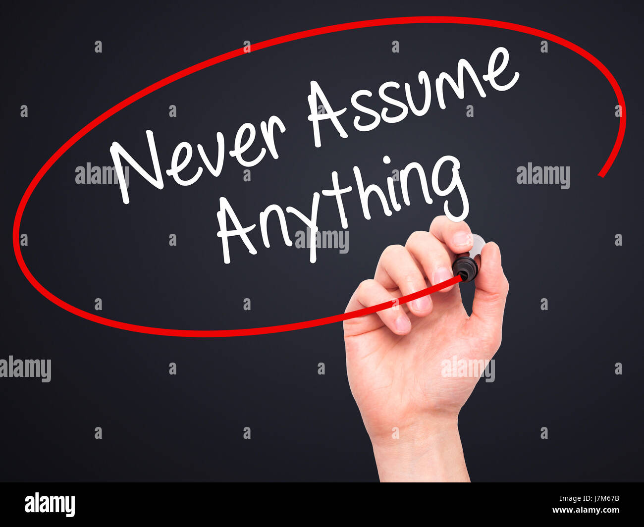 Man Hand writing Never Assume Anything with black marker on visual ...