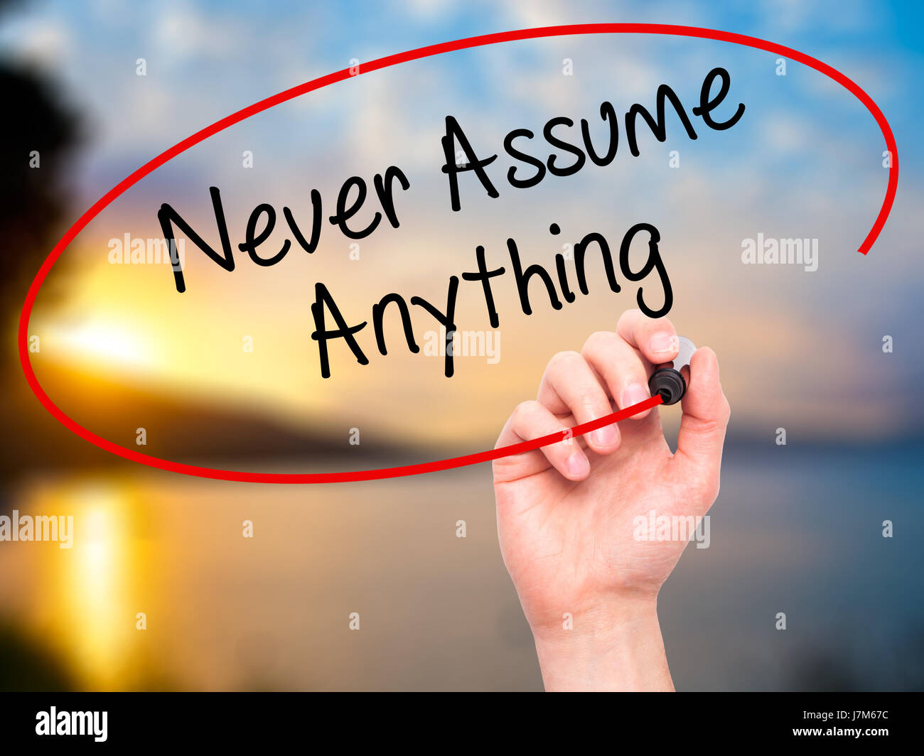 Man Hand writing Never Assume Anything with black marker on visual ...