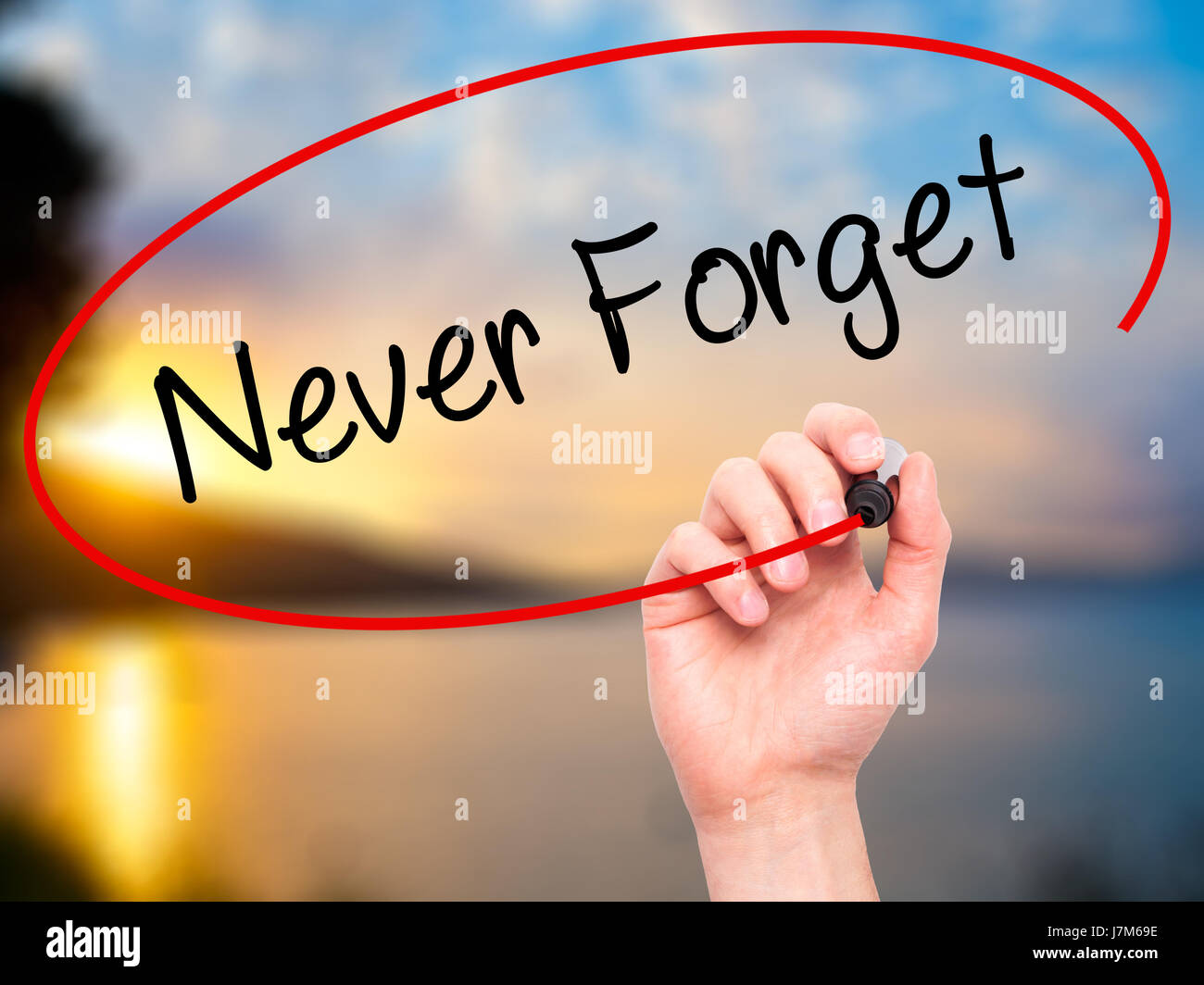 Man Hand writing Never Forget with black marker on visual screen ...