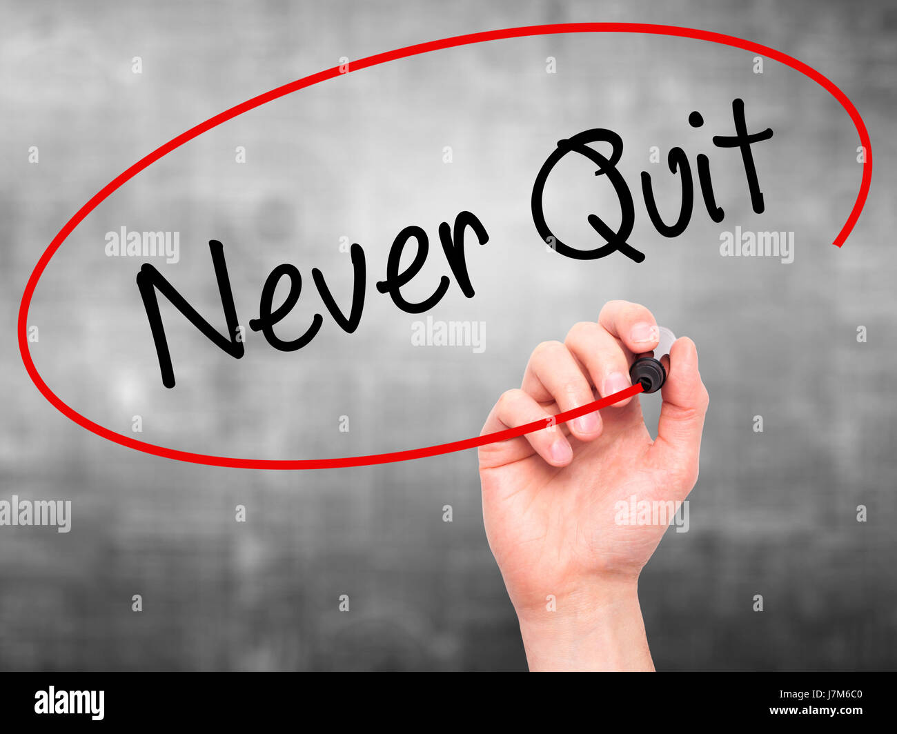 Man Hand writing Never Quit with black marker on visual screen ...