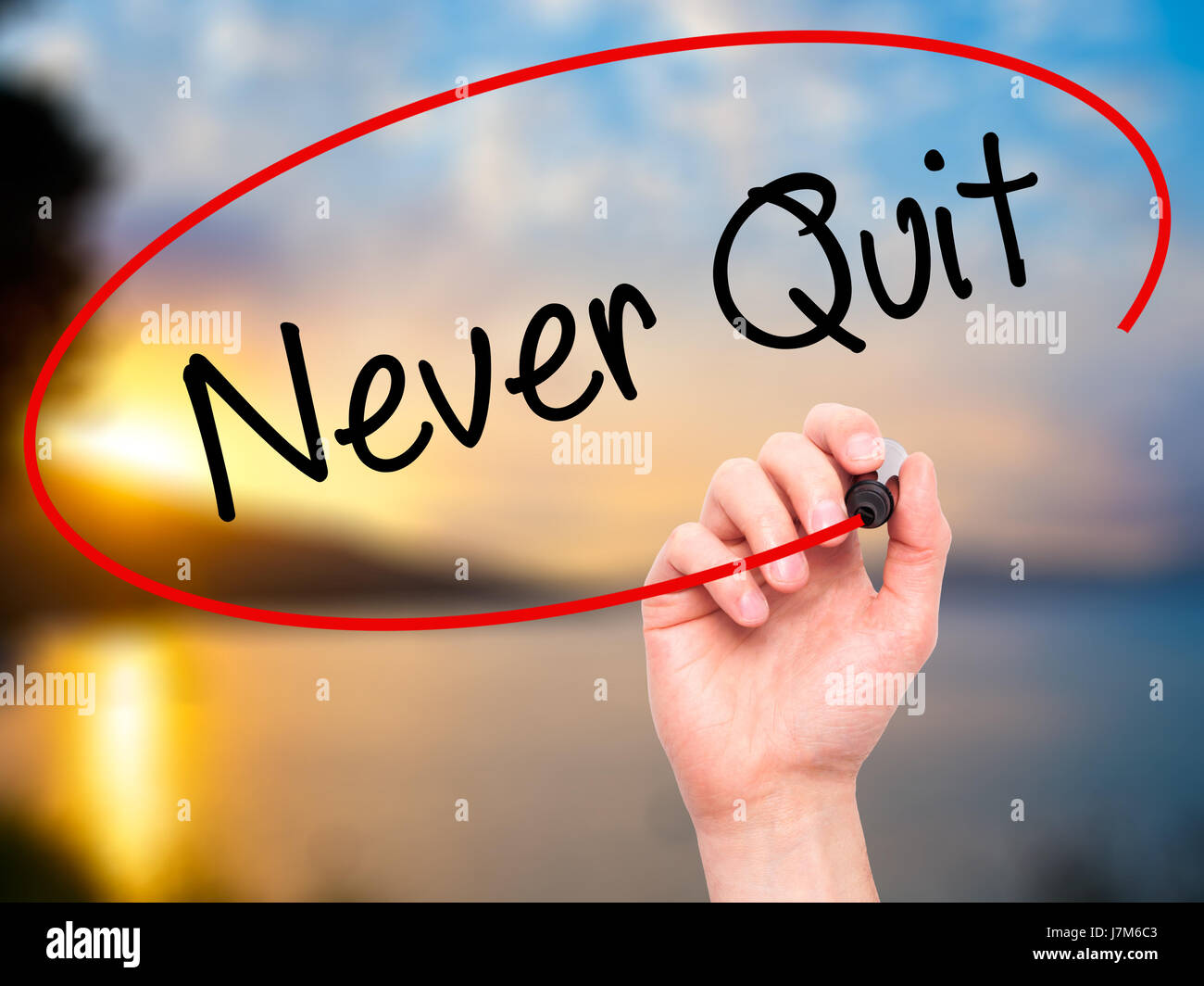 Man Hand writing Never Quit with black marker on visual screen ...