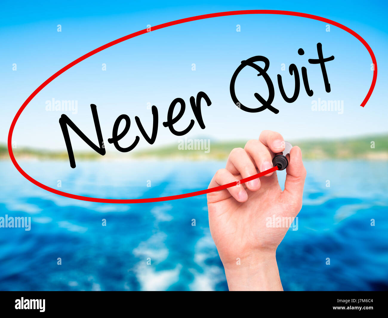 Man Hand writing Never Quit with black marker on visual screen ...