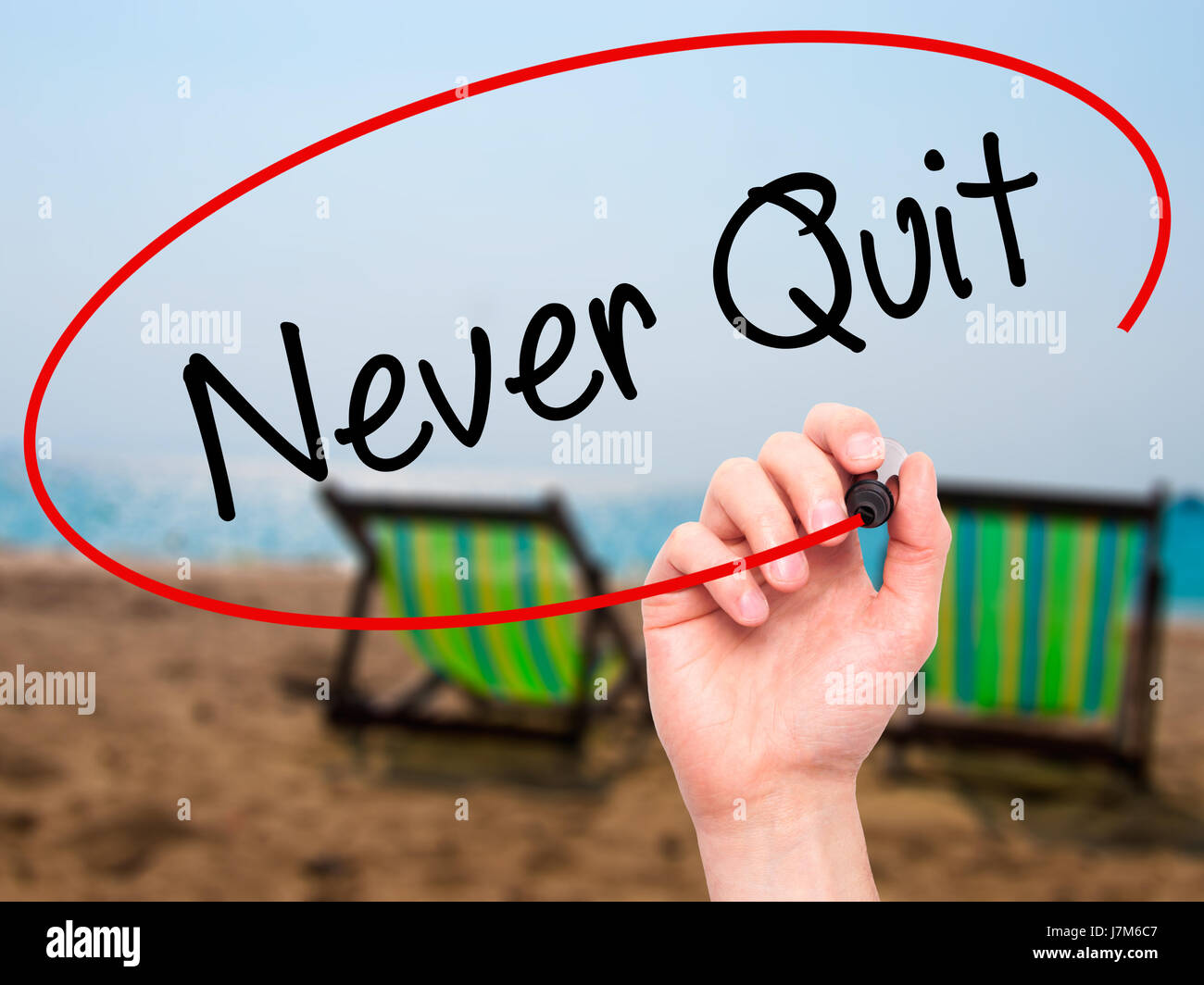 Man Hand writing Never Quit with black marker on visual screen ...