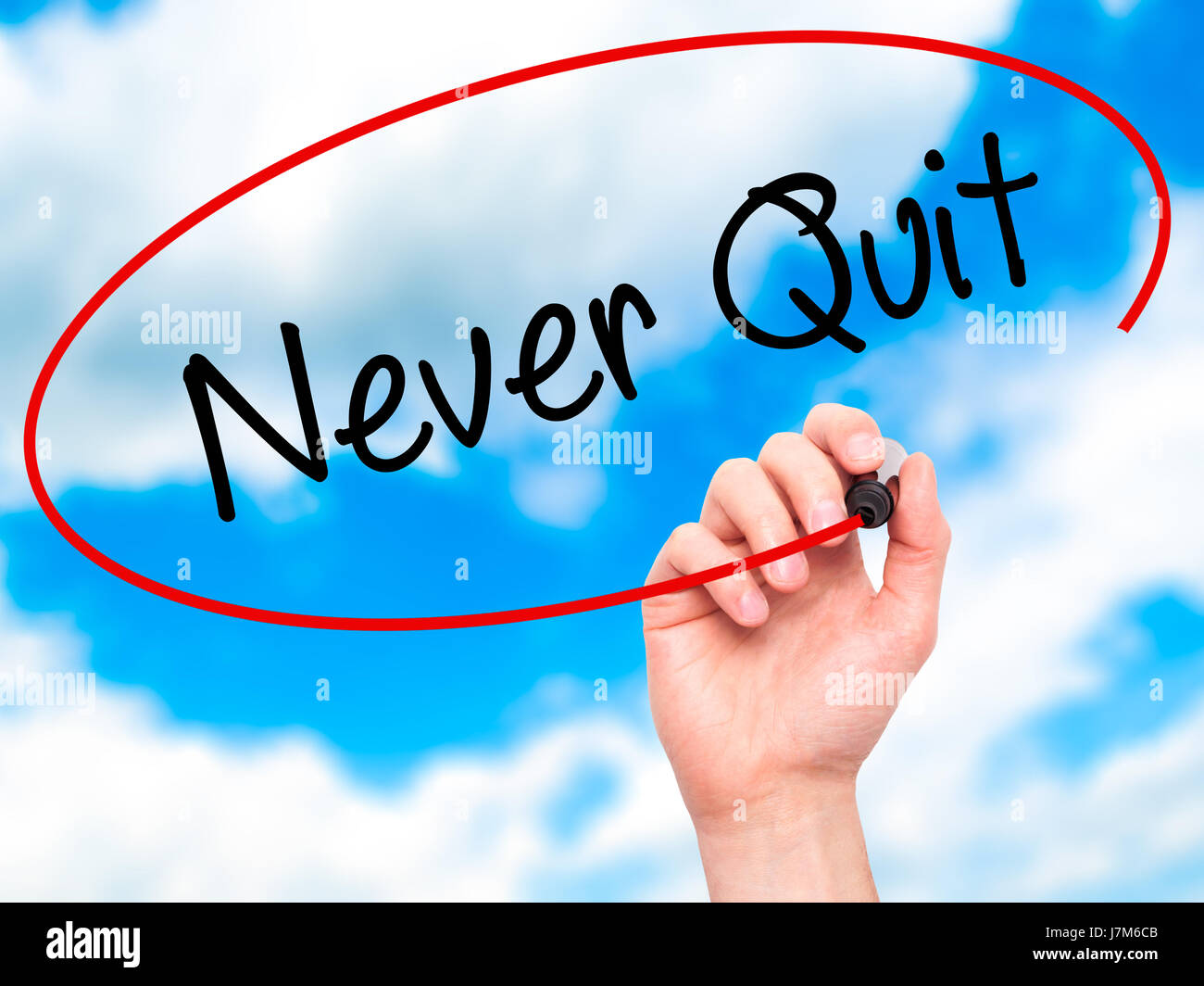 Man Hand writing Never Quit with black marker on visual screen ...