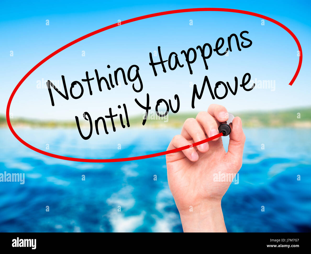 Man Hand writing Nothing Happens Until You Move with black marker on ...