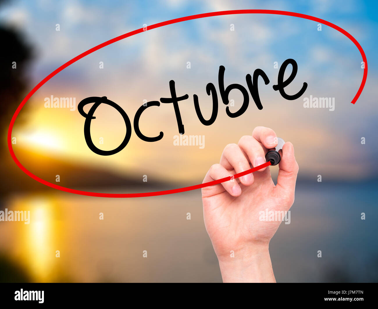 Man Hand writing "Octubre" (In Spanish: October) with black marker on ...