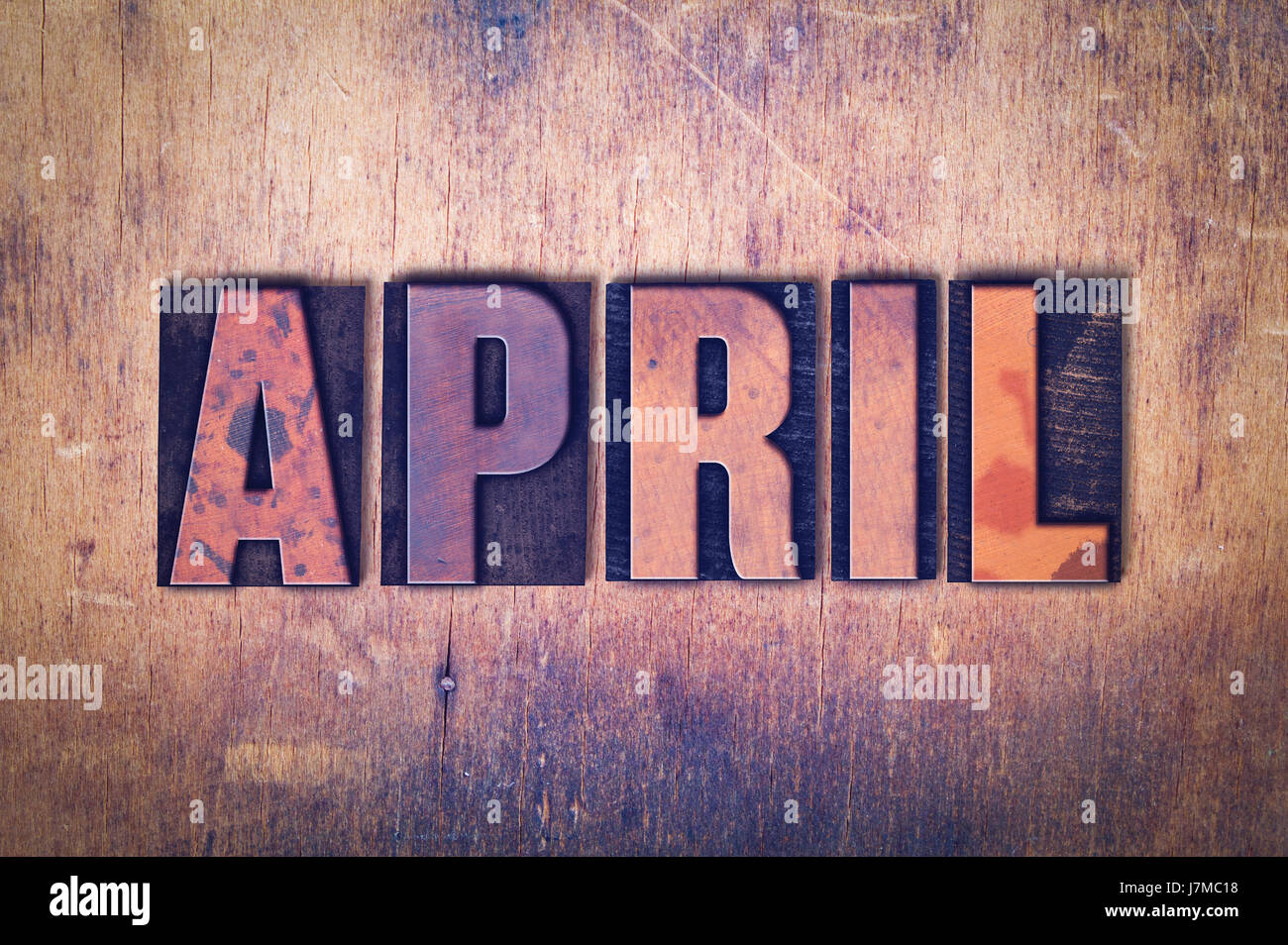 The word April concept and theme written in vintage wooden letterpress ...