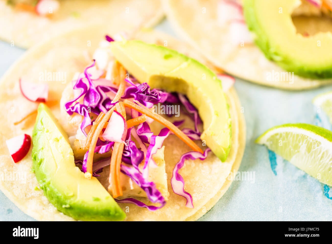 Fresh fish tacos with cod and purple cabbage on a white corn tortillas ...