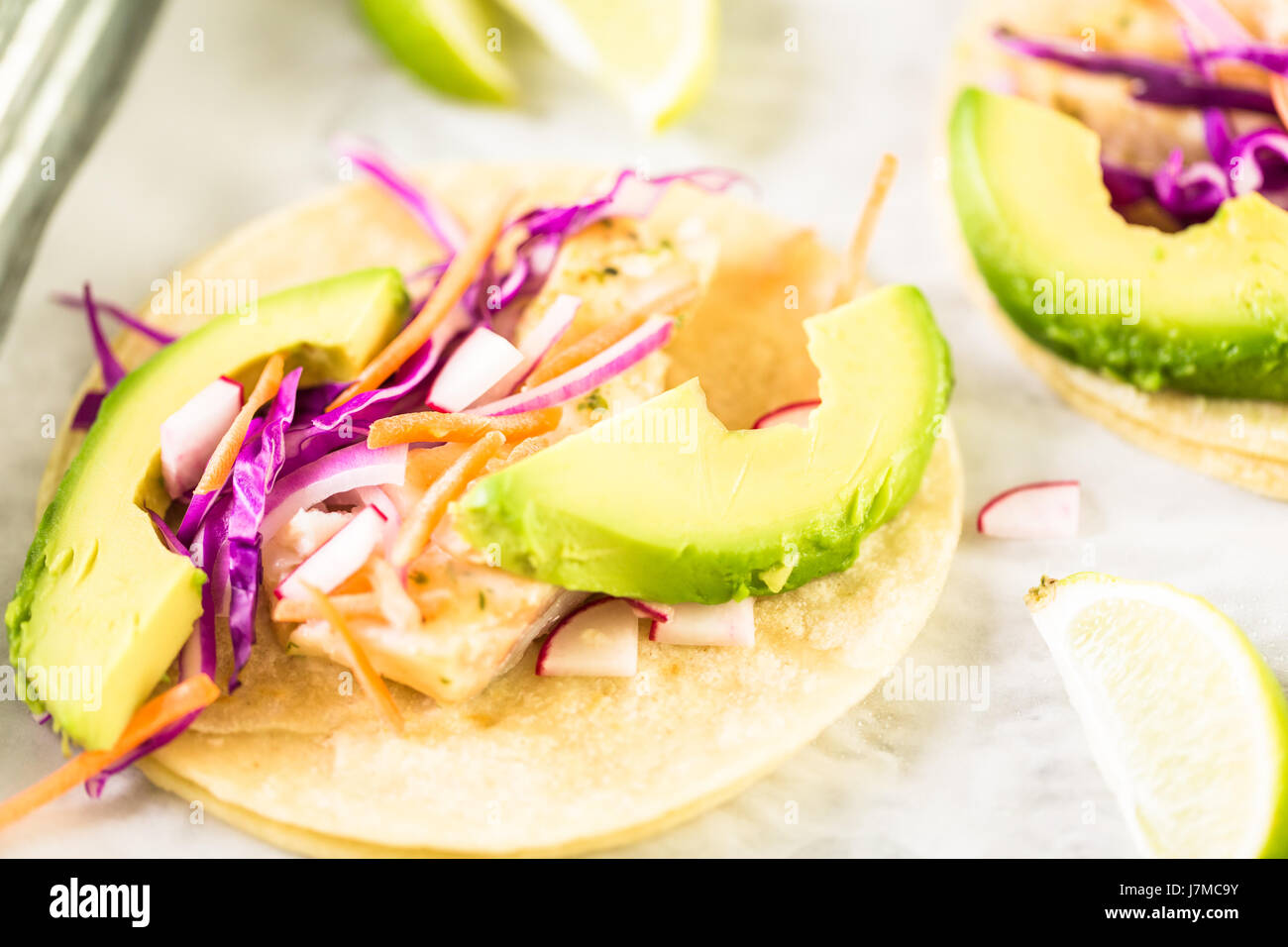 Fresh fish tacos with cod and purple cabbage on a white corn tortillas ...