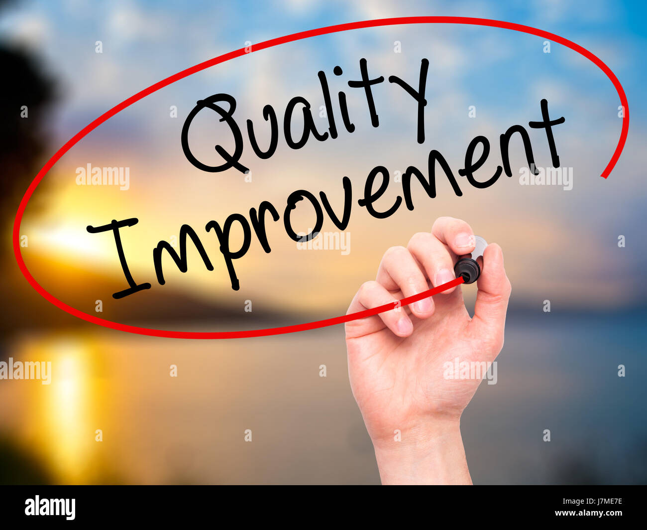 Man Hand writing Quality Improvement with black marker on visual screen ...