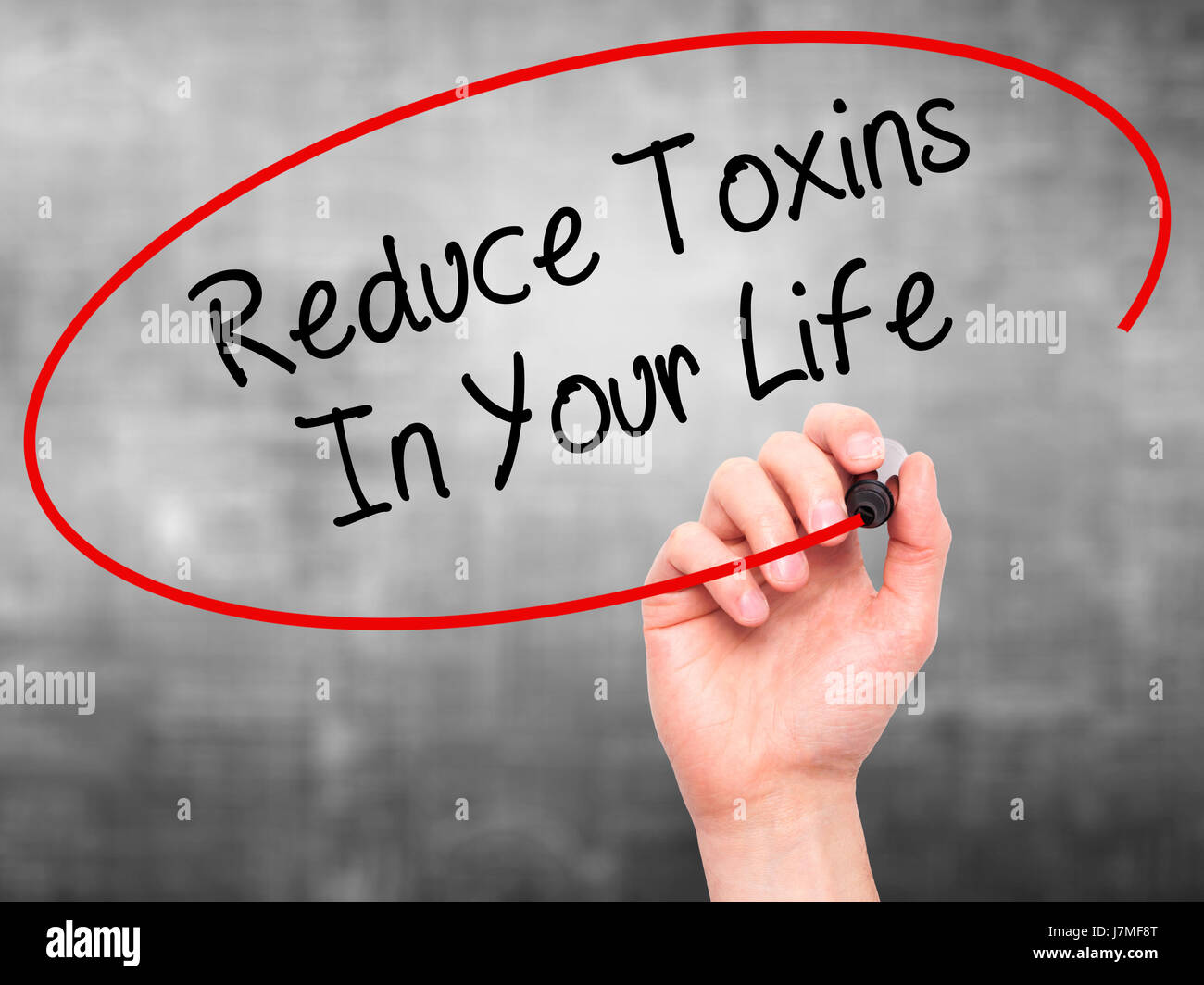 Man Hand writing Reduce Toxins In Your Life with black marker on visual ...