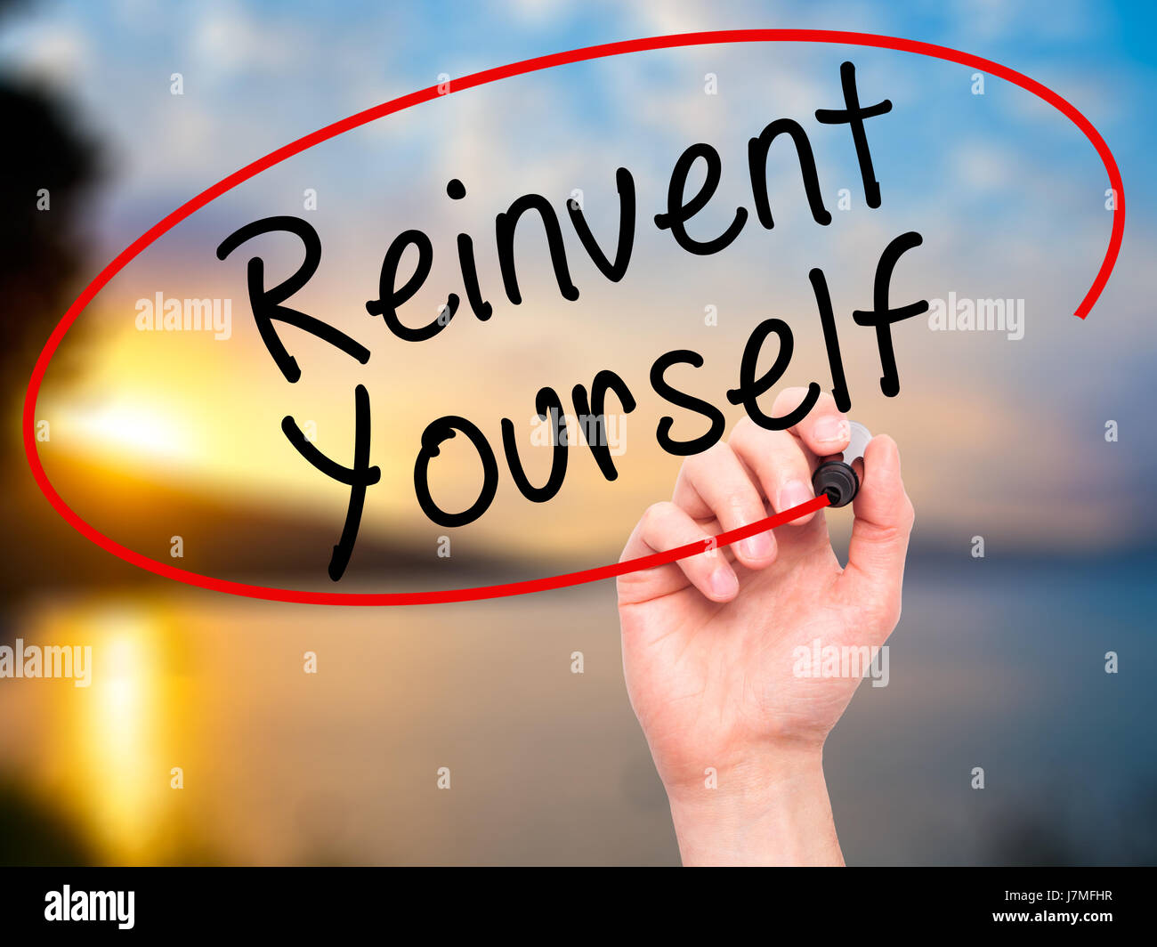 Man Hand writing Reinvent Yourself with black marker on visual screen ...