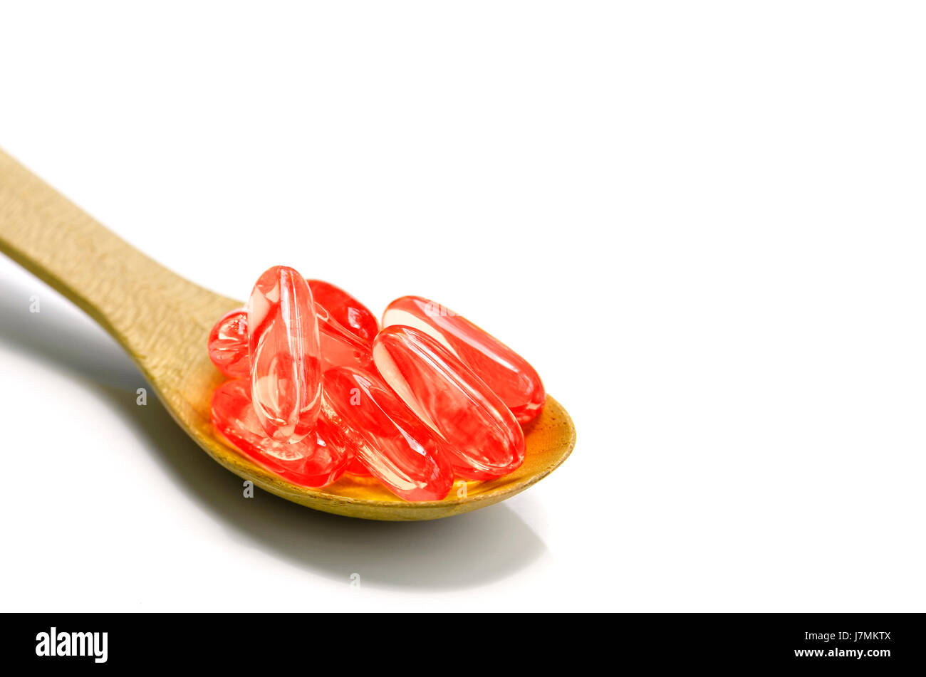 Spoonful of dietary supplement oil capsule isolated on white background ...