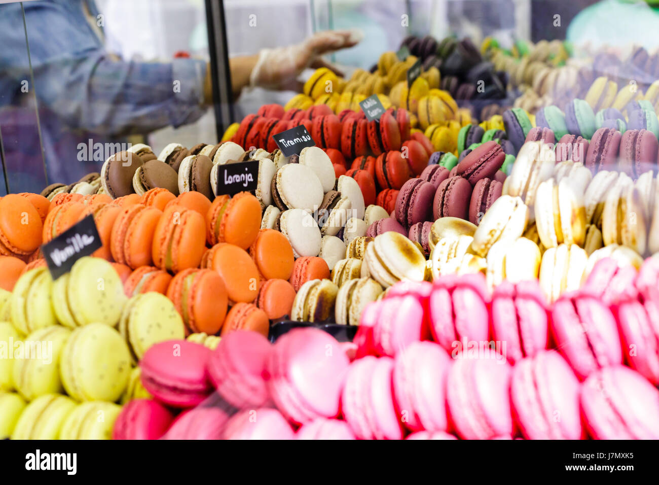 Colorful macarons dessert assortment for sale with a signs saying ...