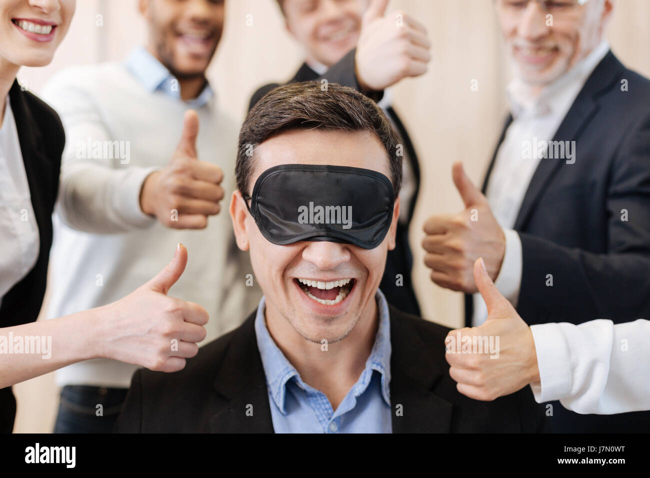 Happy positive man being surrounded by his colleagues Stock Photo - Alamy