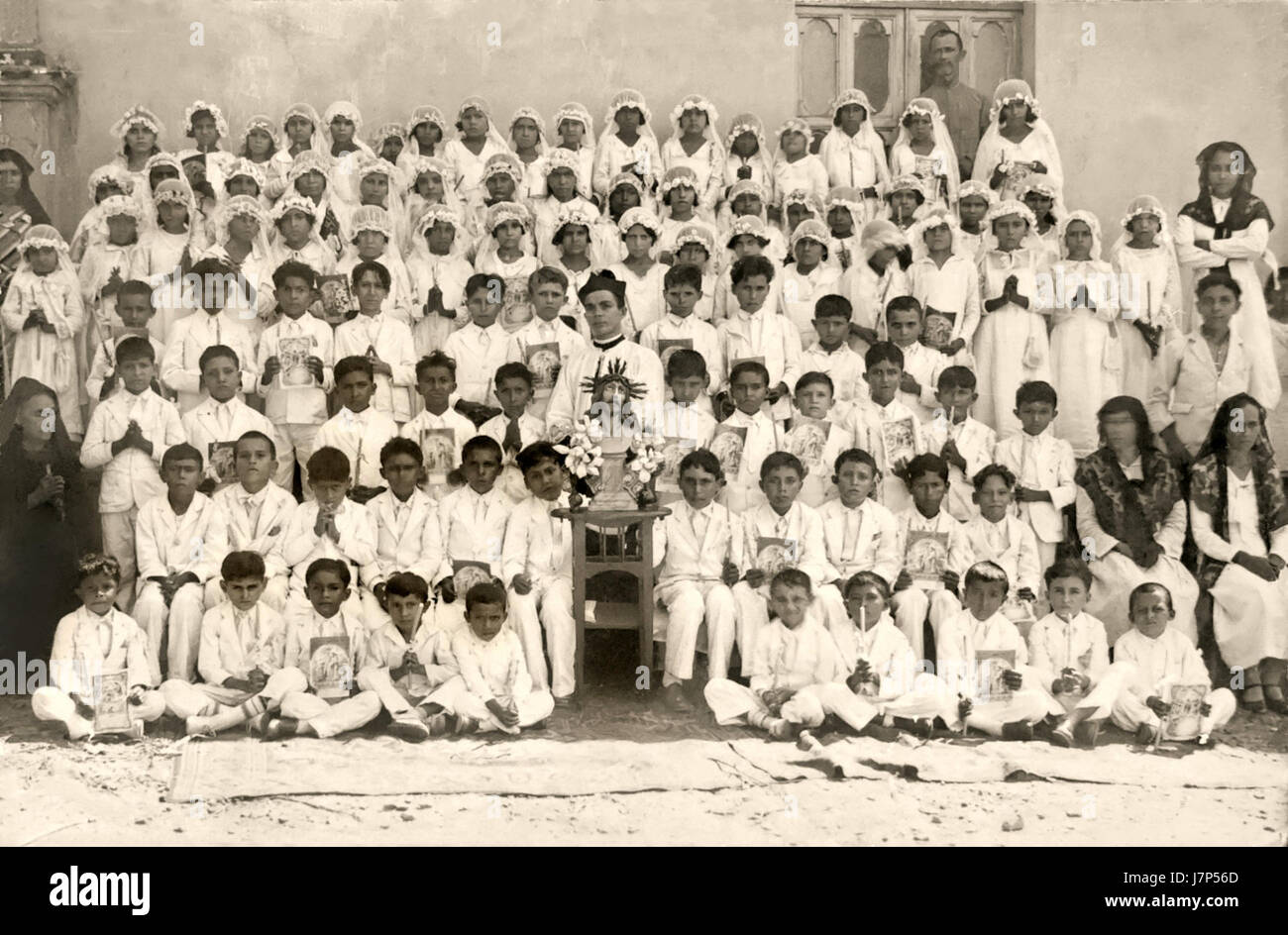 This restored image depicts a First Communion ceremony from 1930. It ...