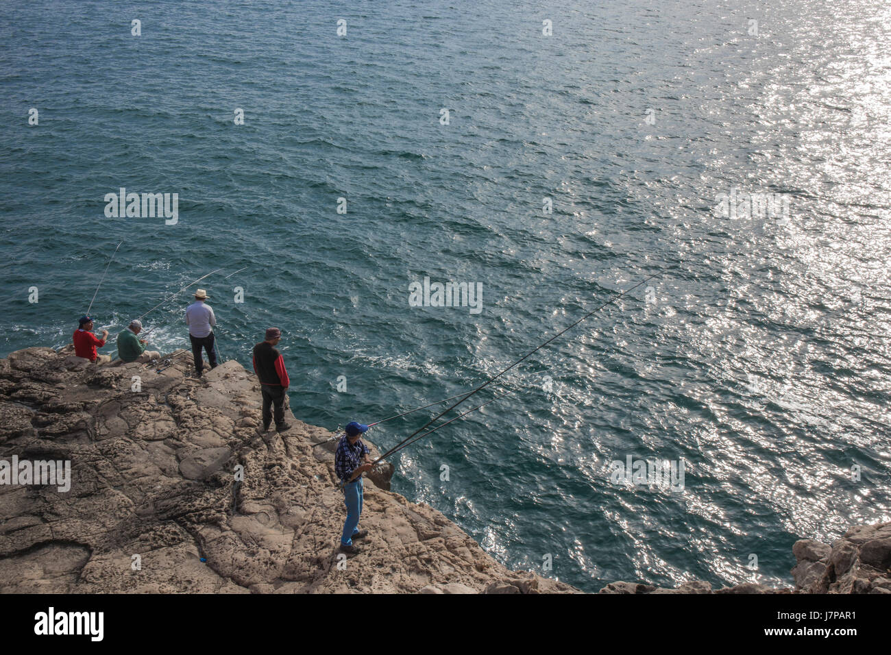 Fishermen fishing on rock Stock Photo - Alamy
