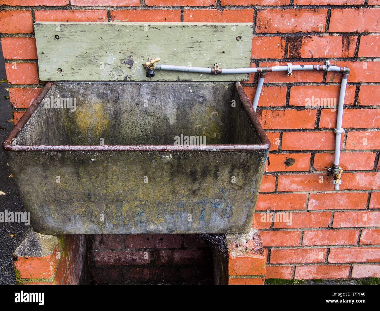 Outdoor Sink On A Red Brick Wall Stock Photo - Alamy