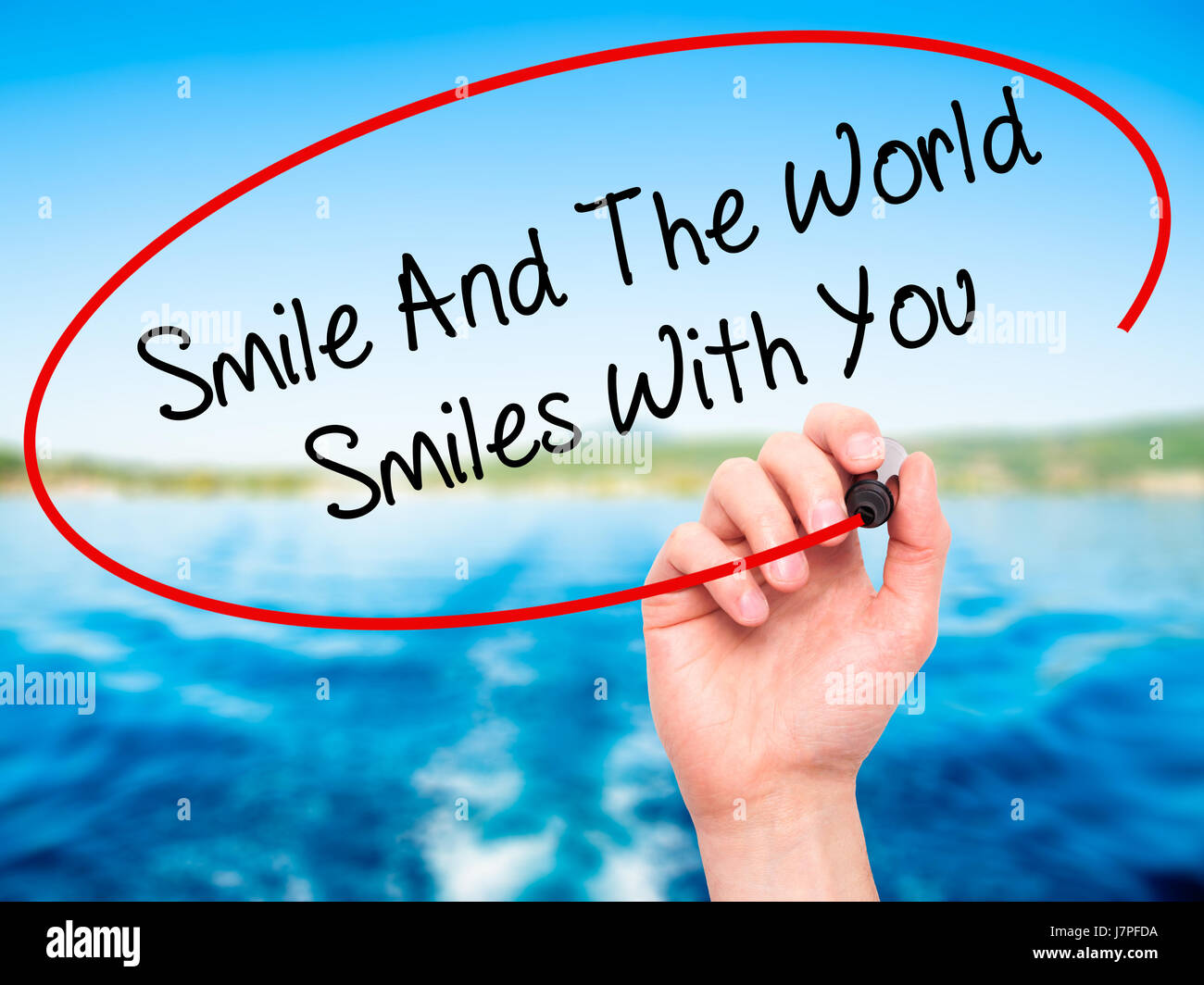 Man Hand writing Smile And The World Smiles To You with black marker on ...
