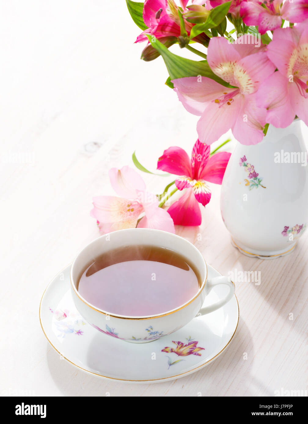 Retro still life with cup of tea and flowers (Alstroemeria Stock Photo ...