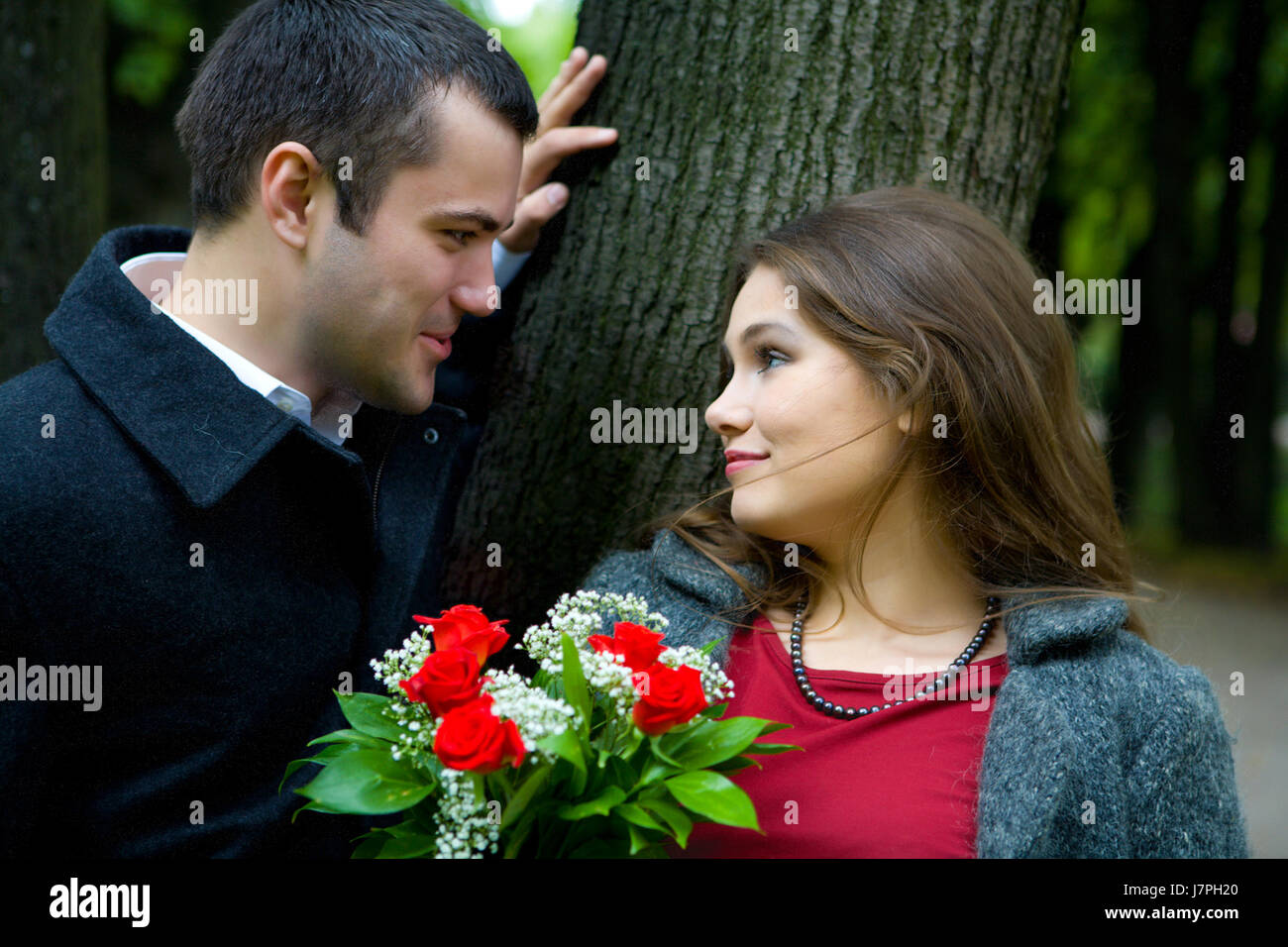 Two young lovers talking to each other in park Stock Photo - Alamy