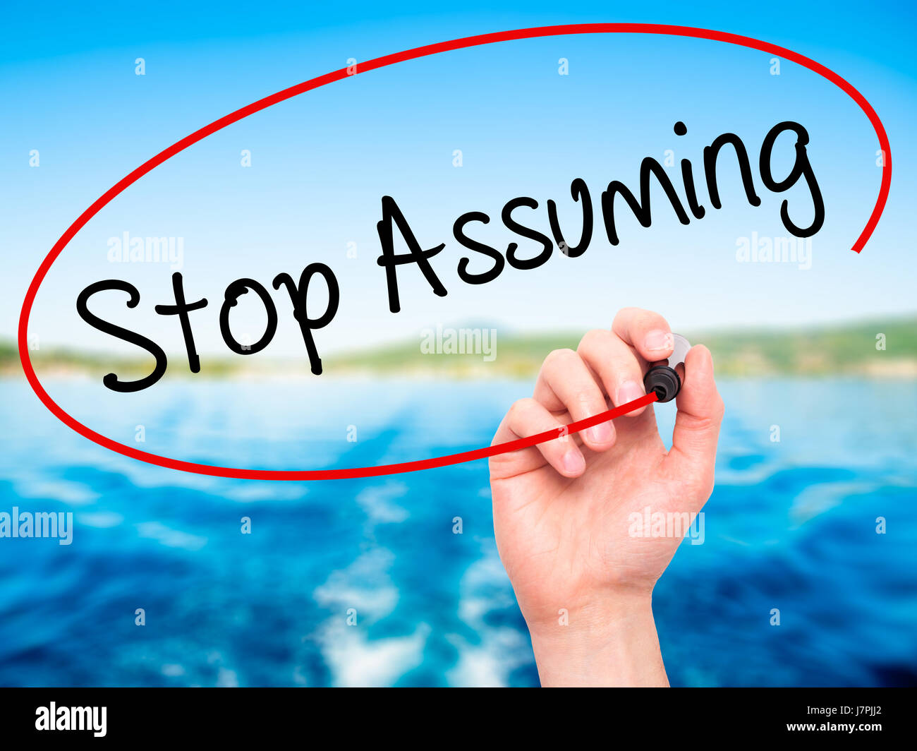 Man Hand writing Stop Assuming with black marker on visual screen ...