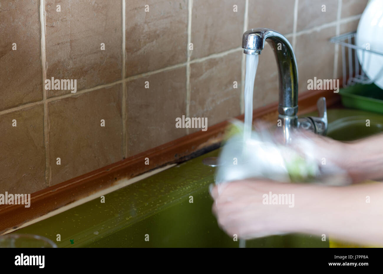 Hands washing dishes on a kitchen sink with faucet flowing water Stock ...