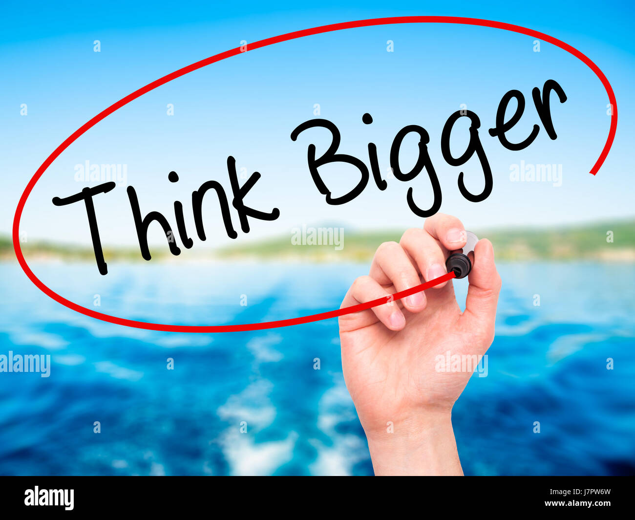 Man Hand writing Think Bigger with black marker on visual screen ...