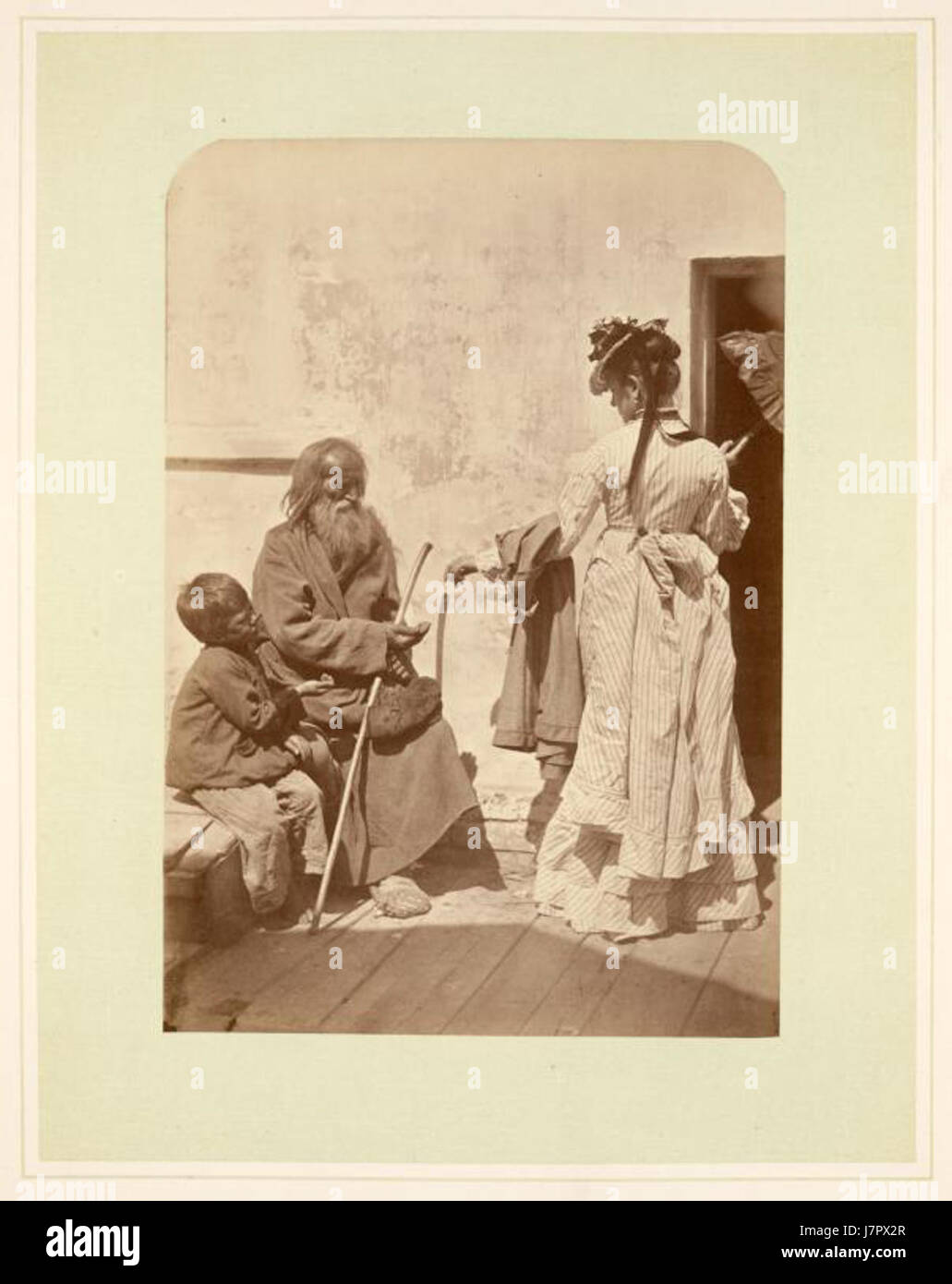 This image portrays a woman, dressed in fashionable attire, giving alms ...