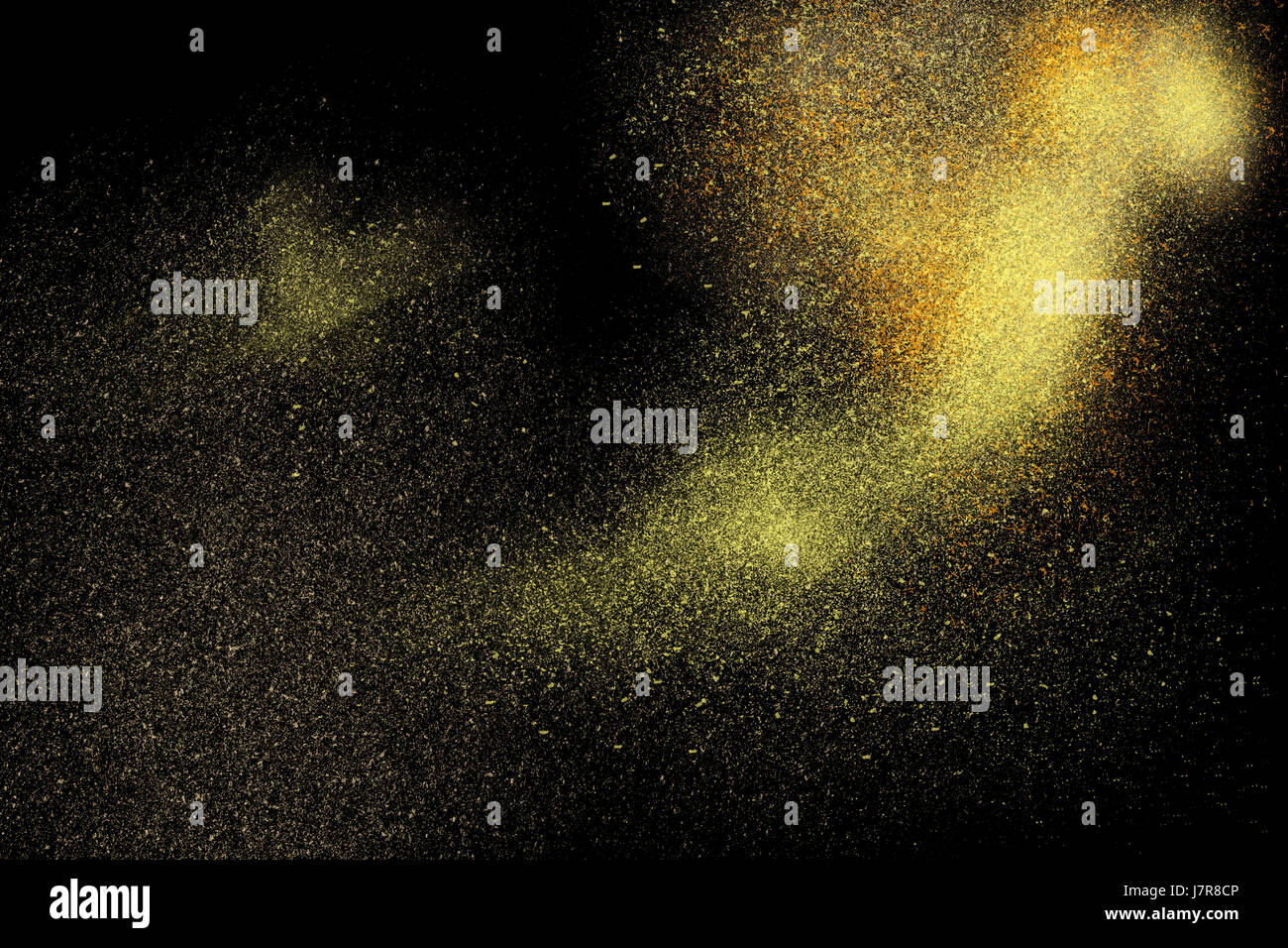 Freeze motion of yellow powder exploding, isolated on black, dark ...